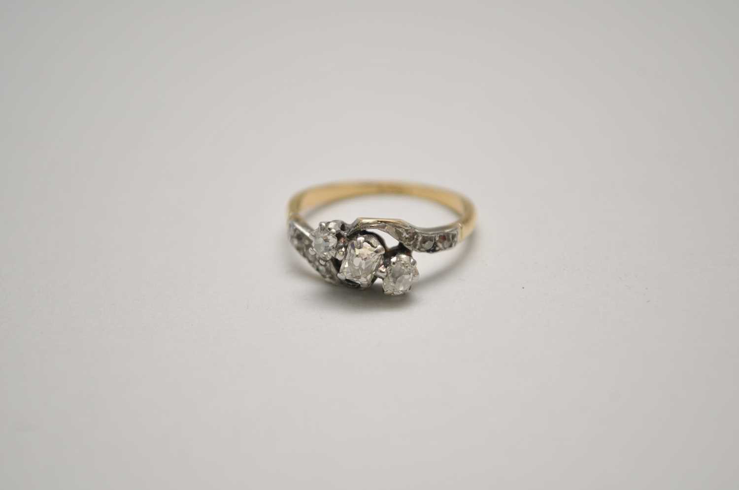 Lot 126 - A three stone diamond cross over ring