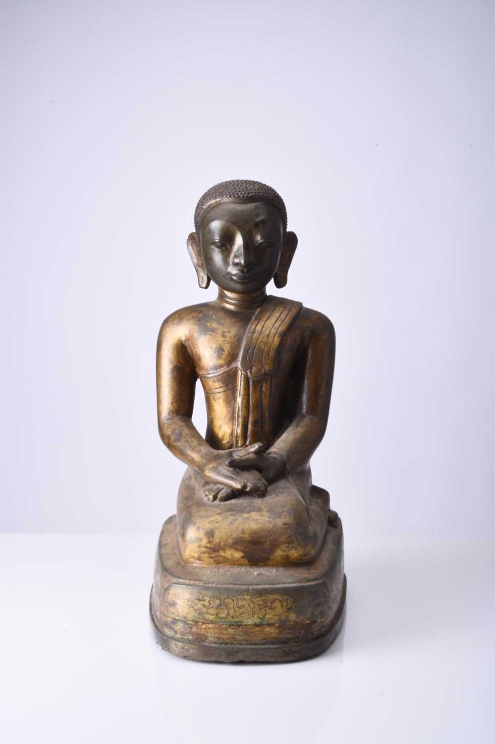 Lot 90 - A Burmese gilt bronze figure of a seated monk,